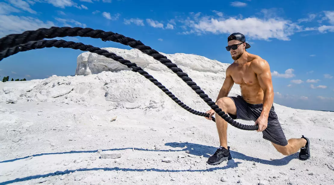 Physical-Fit-Man-Workingout-Outdoor-On-A-Mountain-Doing-Battle-Rope-Esercizi