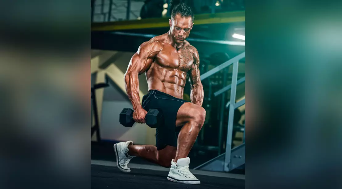 Bodybuilder manao dumbbell lunge