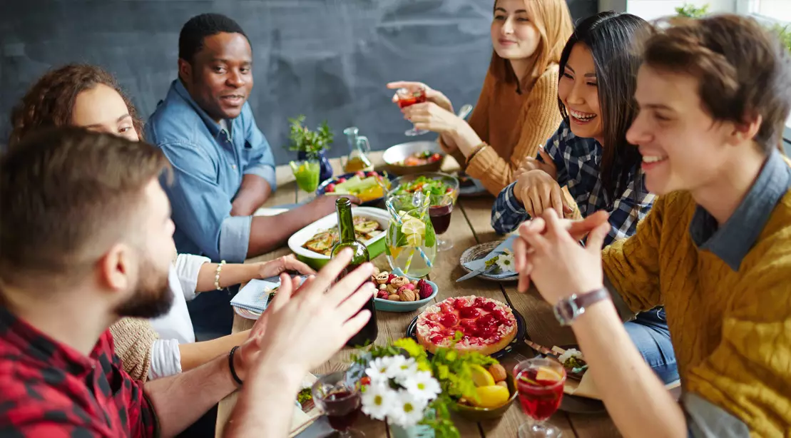 Vänner-samlades-runt-middag-bord-måltid