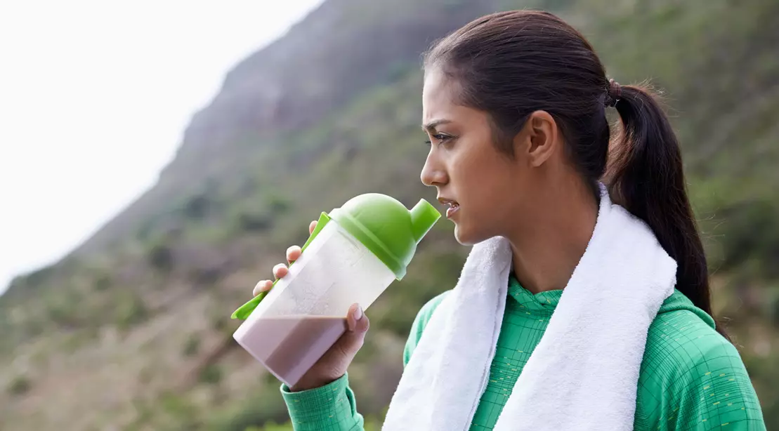 Kvinna som dricker en proteinshake