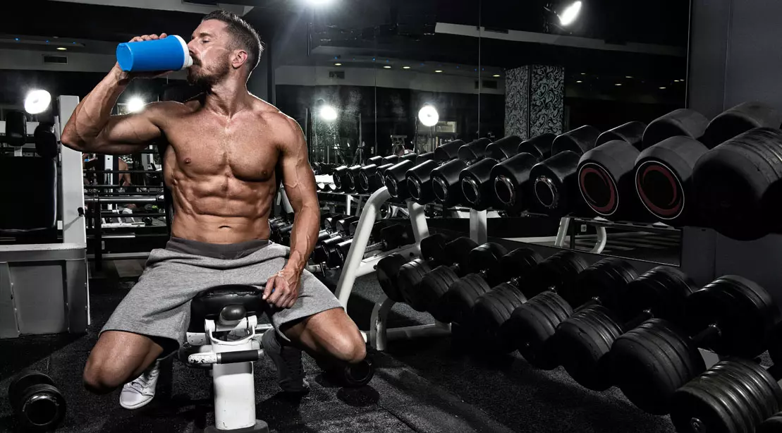 Homme buvant un shake protéiné dans la salle de gym