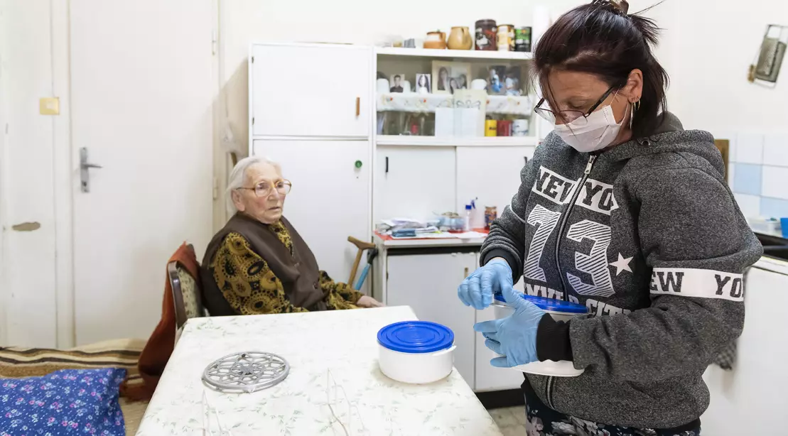 Femme-aidant-une-personne-âgée-femme-à-la-maison-portant-des-gants-et-un-masque-facial