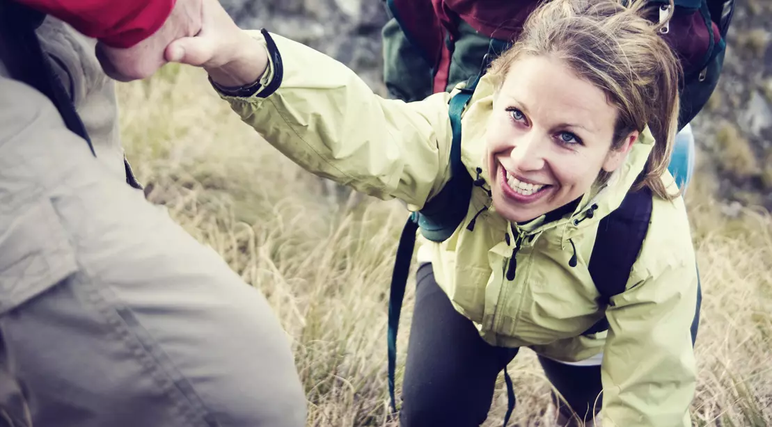 Girl-Being-Helped-Hiking-Scramble-Backpacking