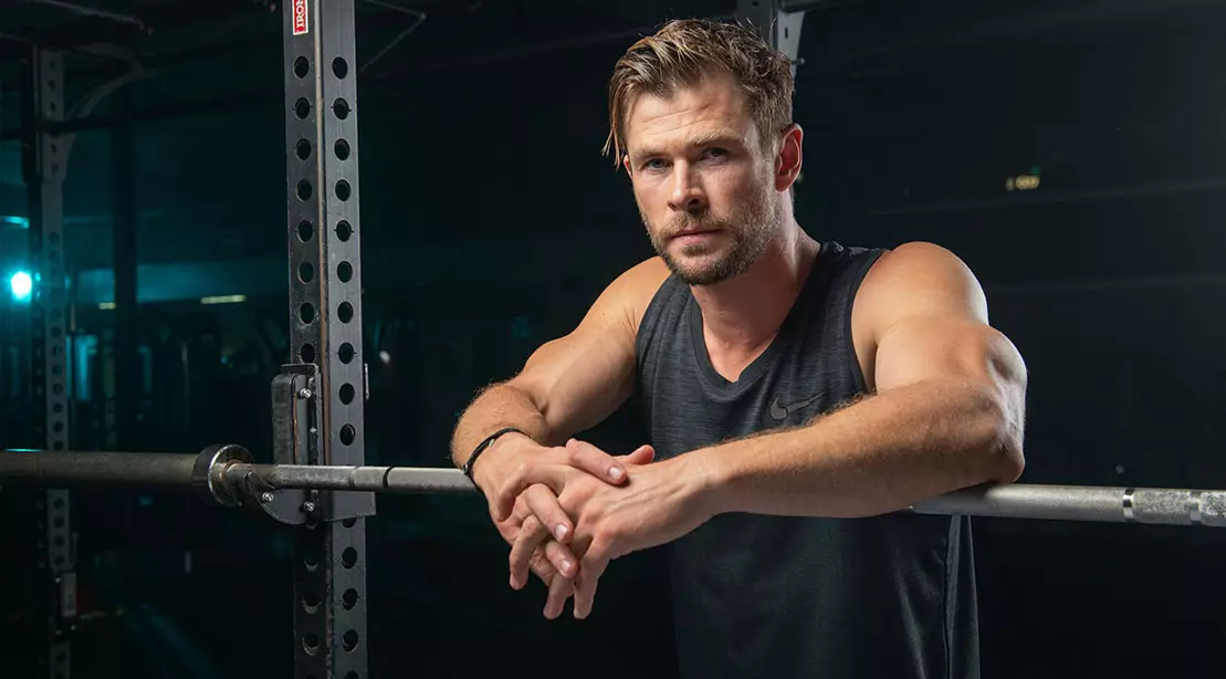 L-attur Chris Hemsworth jistrieħ fuq barbell bar wara l-workout ta' ċirkwit tal-piż tal-ġisem ta' 10 minuti