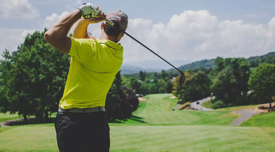 Ang magdudula nga nagsul-ob og titleist nga kalo nga nag-swing sa usa ka hybrid nga golf club gikan sa tee box nga adunay perpekto nga gikan aron malikayan ang mga kadaot sa golf.