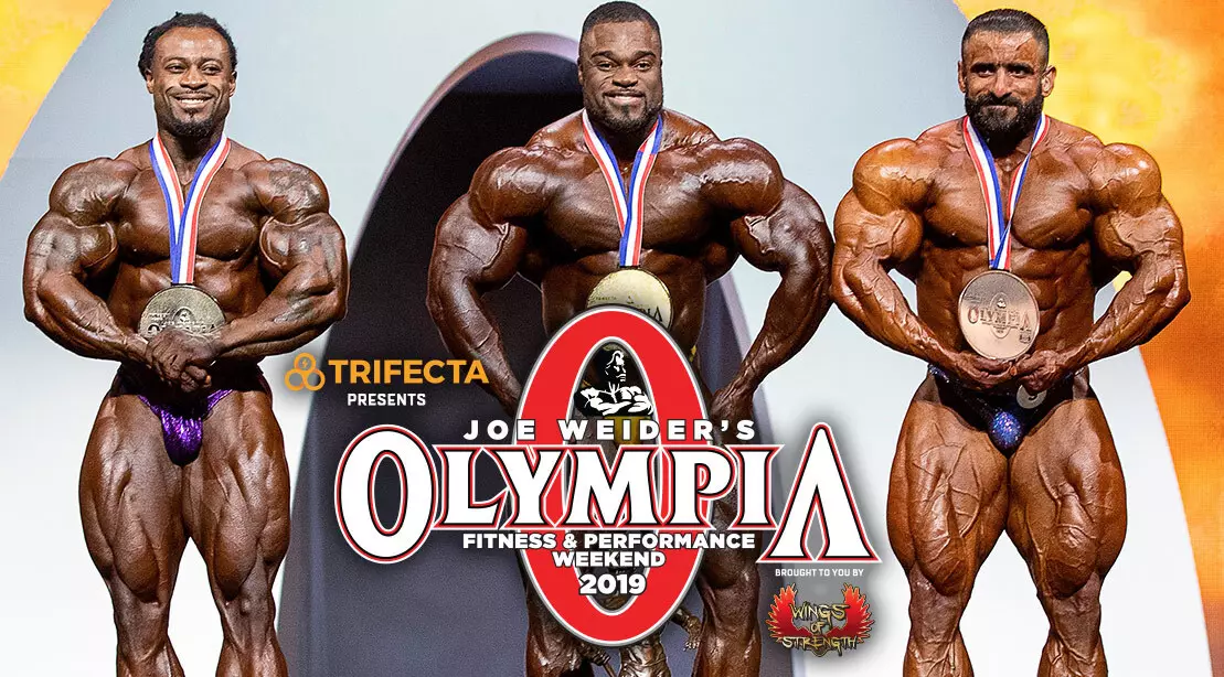 Olympia-Bodybuilders-Wiliam Bonac Brandon Curry akiwa amesimama kwenye jukwaa la Olympia