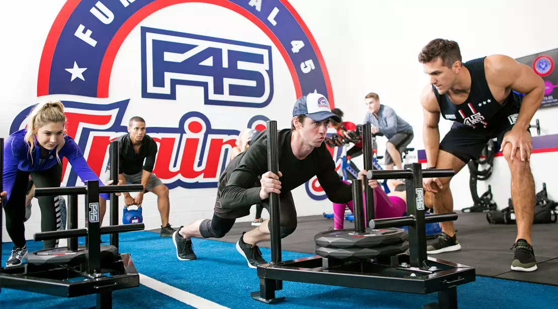 F45 කණ්ඩායම් යෝග්‍යතා පන්තියක sled pushs කරන මිනිසෙක්