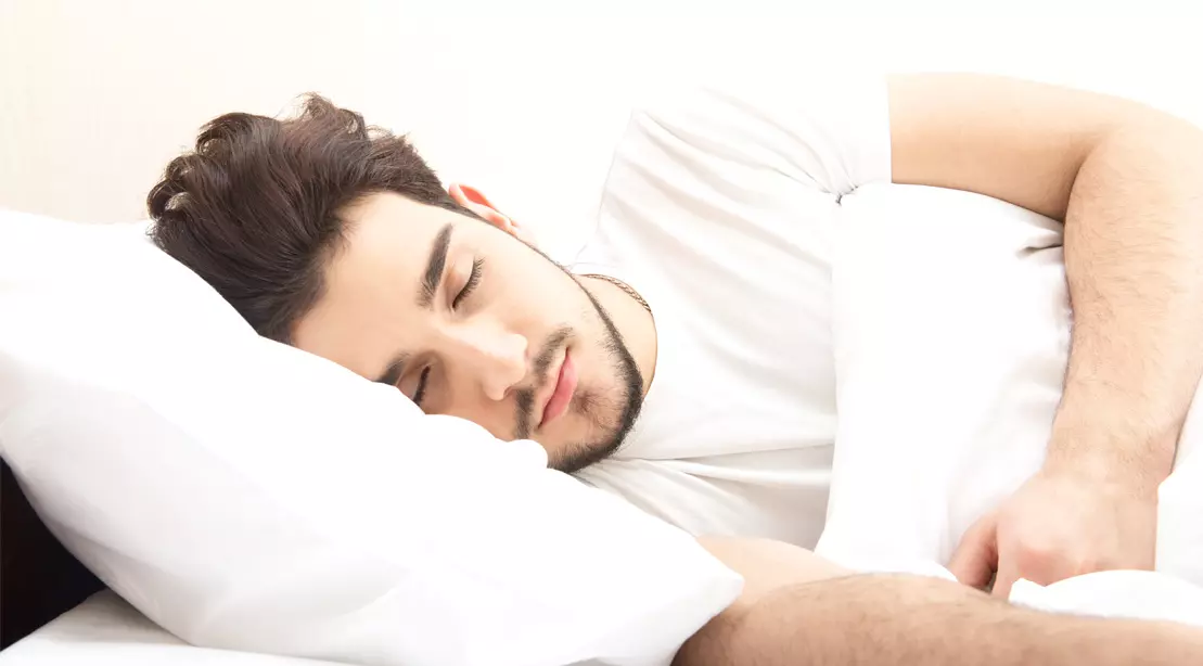 Uomo che dorme profondamente e comodamente ai lati del letto