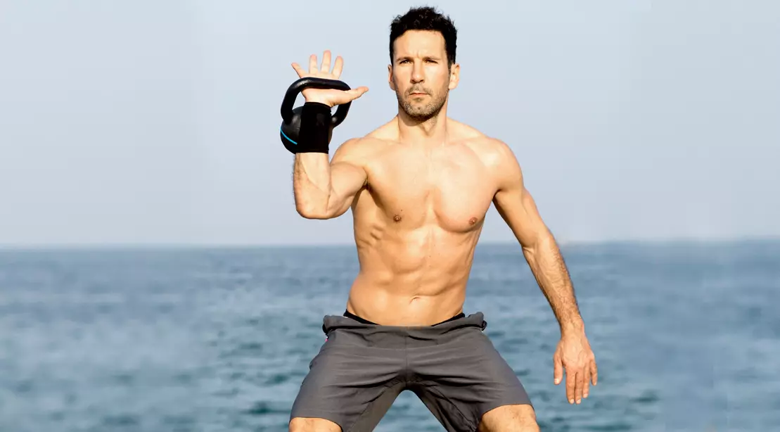 hombre-en-la-playa-levantando-una-kettlebell