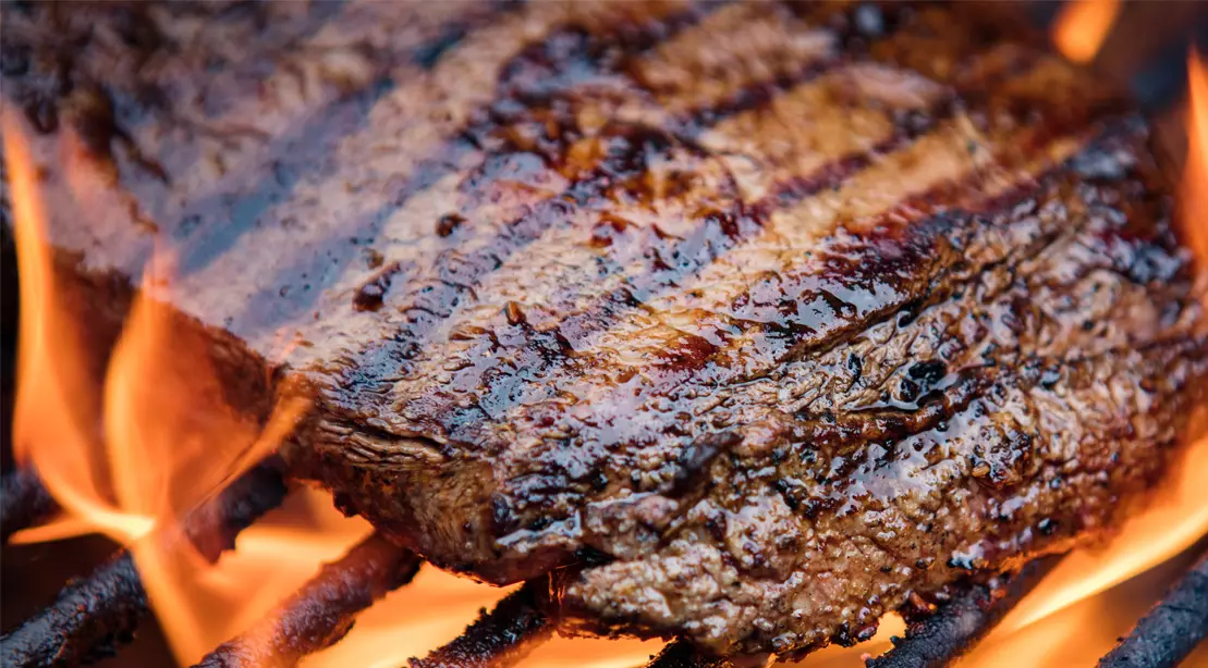 Skjørtbiff grilling på en grill med en omvendt bruning