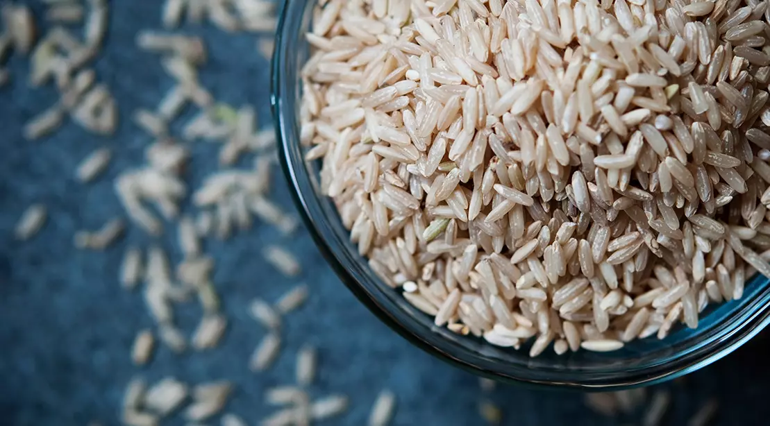 Mangkok ng brown rice na nakaupo sa isang asul na mesa