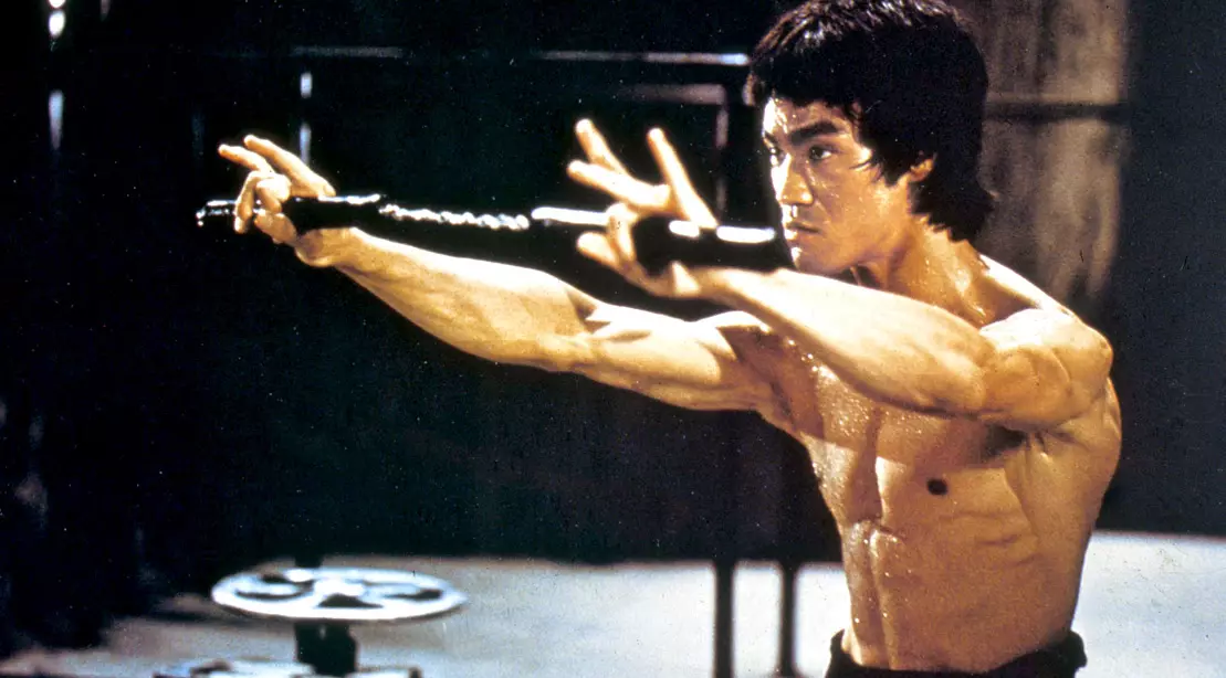 Võitluskunstnik ja kung fu legend Bruce Lee hoiab Nunchucksi üleval