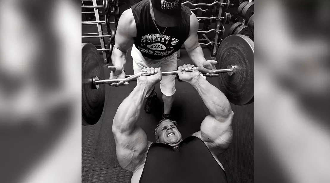 O fisiculturista e vencedor do Mr. Olympia Jay Cutler exercitando os músculos do tríceps com um supino com pegada fechada com um observador