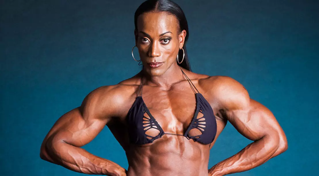 Vrouwelijke bodybuilder en mevrouw Olympia Lenda Murray dragen een zwarte bikini