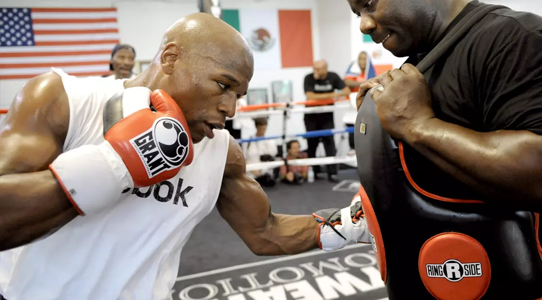 El boxejador Floyd Mayweather entrenant contra un entrenador que portava un protector corporal