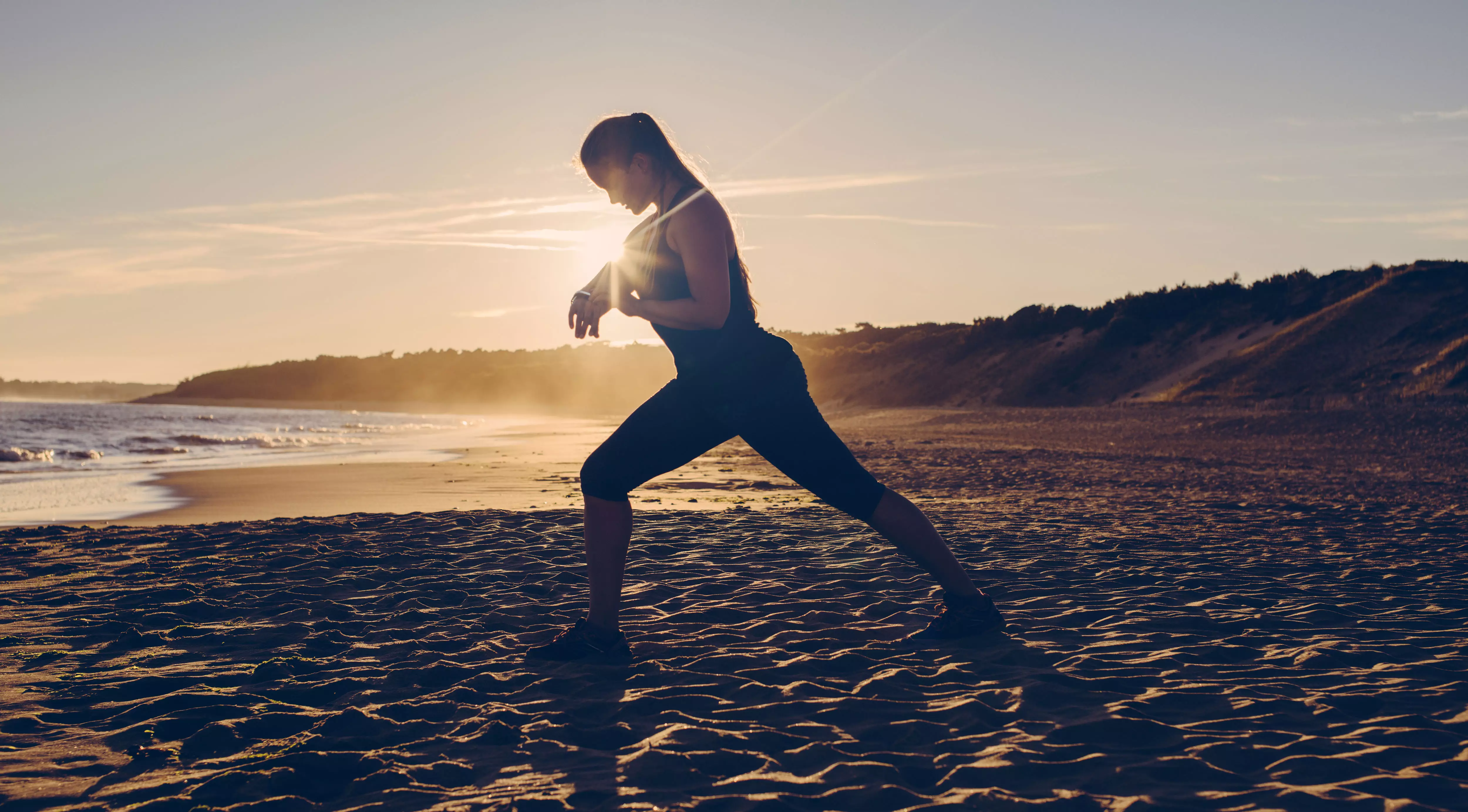 Vrouw die zich uitstrekt op het strand