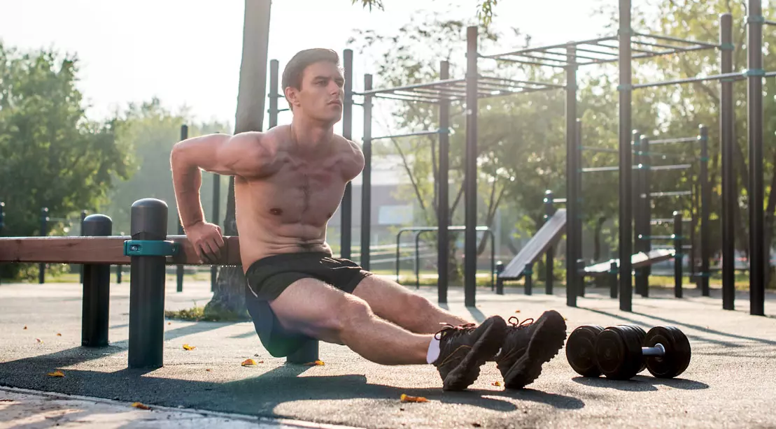 Fit männlech mécht dee beschten Triceps Workout mat enger Bank Dip Übung