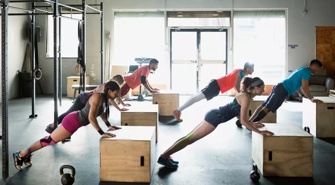 Grup de fitness care face cel mai bun antrenament pentru tricepși cu exerciții de pushup cu box