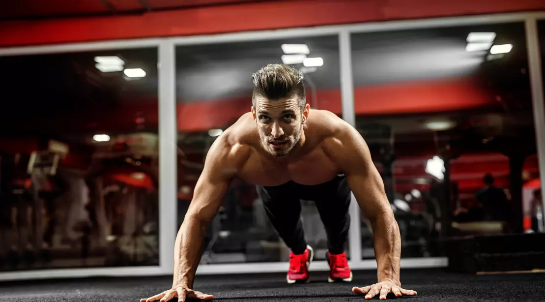 Mann mécht Pushups Am Gym