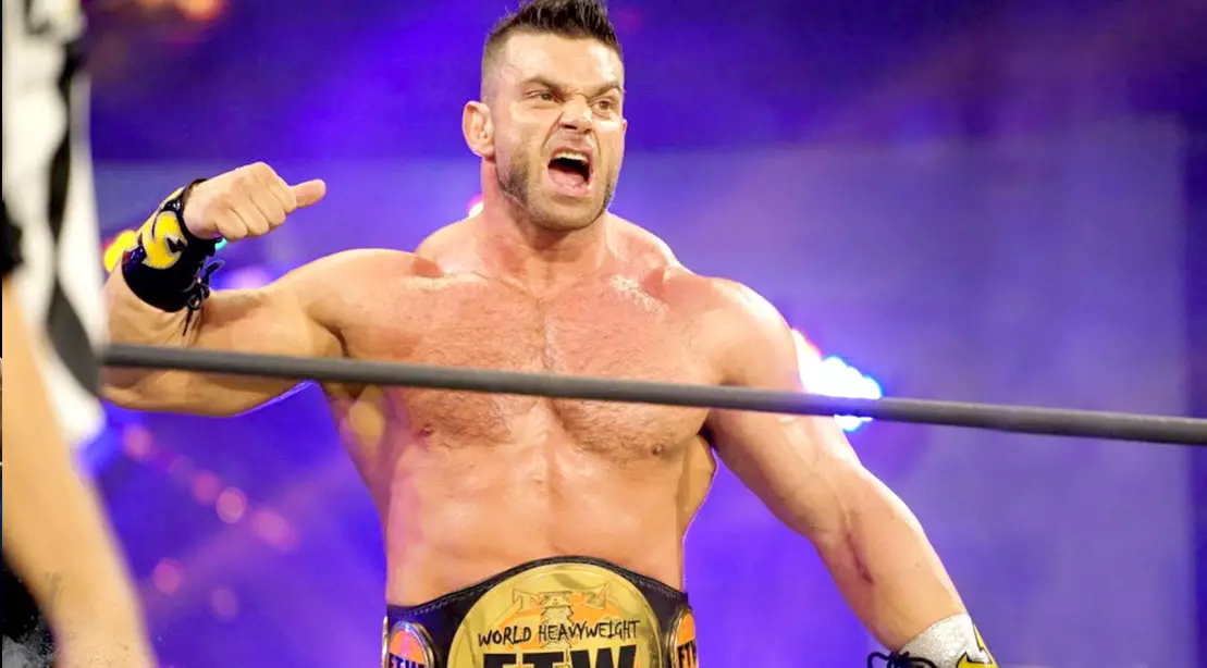 Tot luptătorul profesionist de Elite Wrestling, Brian Cage, poartă centura AEW Heavy Weight Belt