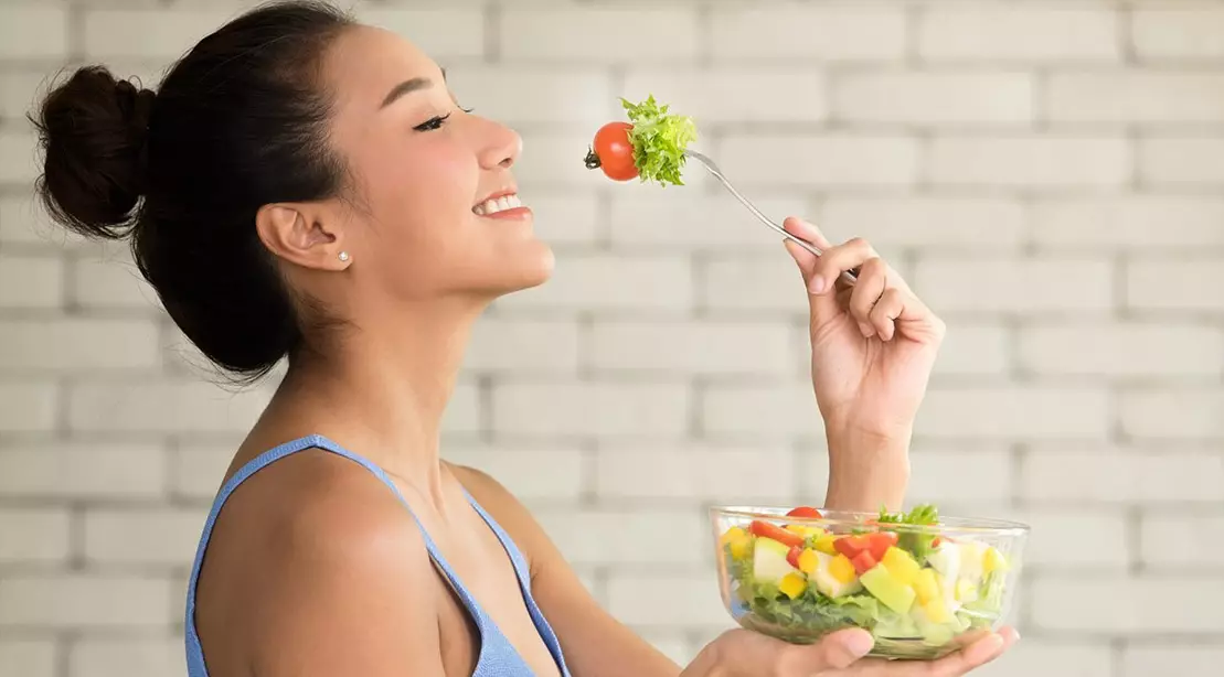 Batang babae na kumakain ng salad