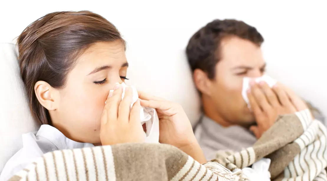 Casal Doente Na Cama Assoando o Nariz