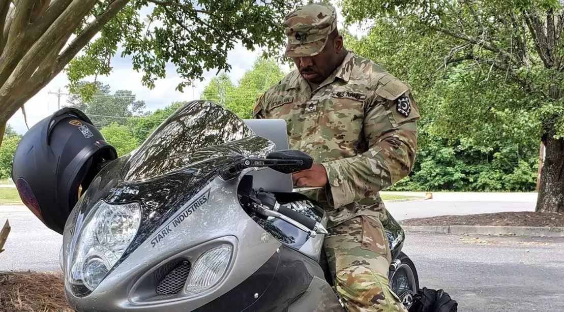 Bodybuilder Cedric McMillan in zijn legeruniform op een motorfiets