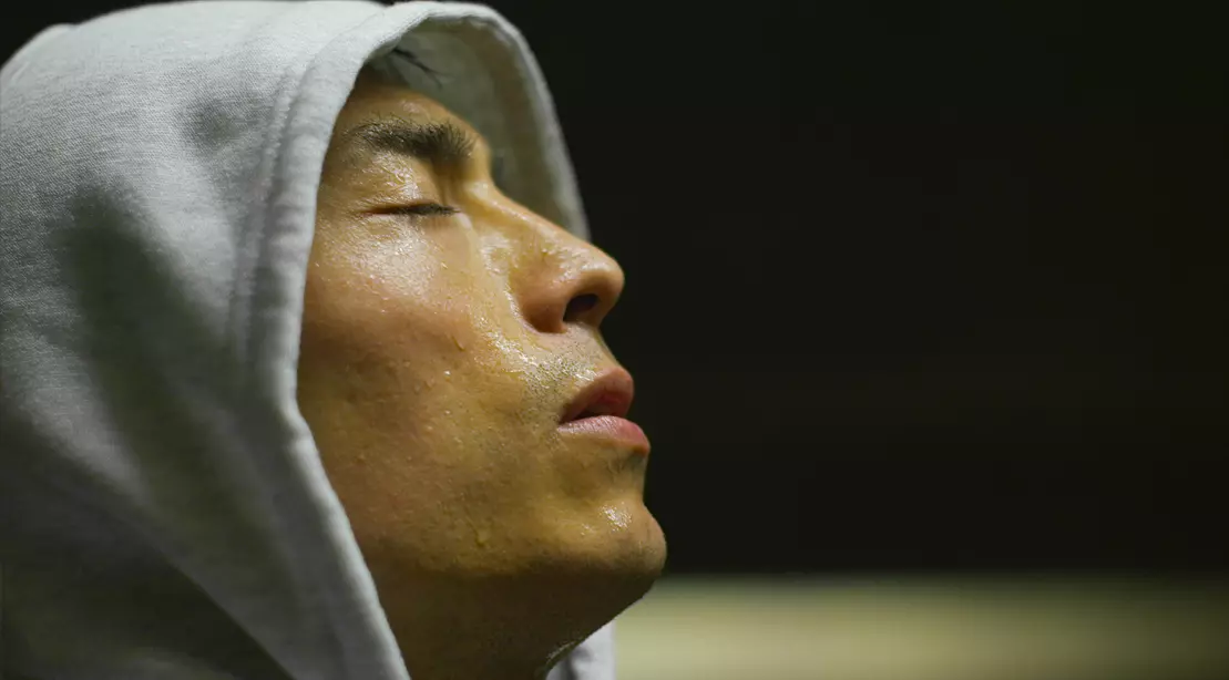 Asian-Man-Wearing-Hoodie-Closed-Eyes