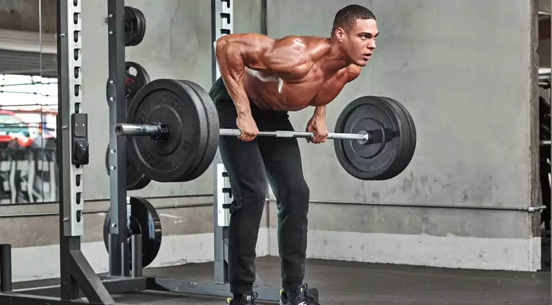 Model de fitness treballant l'esquena fent una barra inclinada sobre exercici de fila